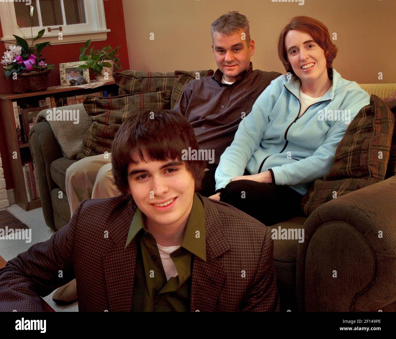 Mike, left, and Michelle Riley pose for portrait with their son ...