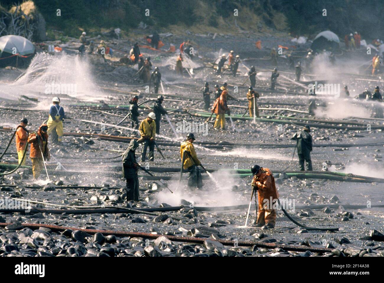 Exxon Valdez oil spill workers use pressure washers to wash oil from ...