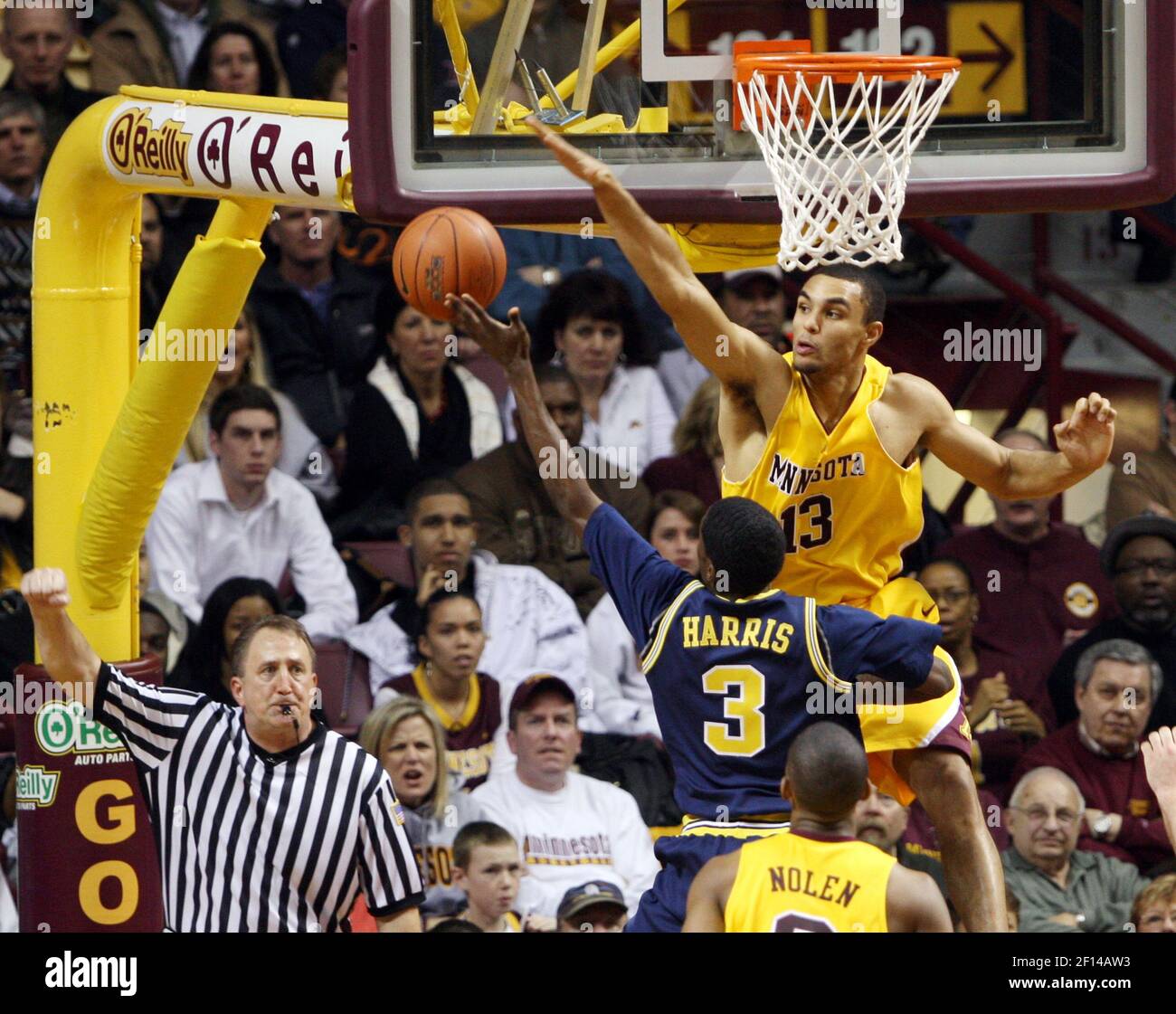 Minnesota's Dan Coleman blocks a shot by Michigan's Manny Harris late ...