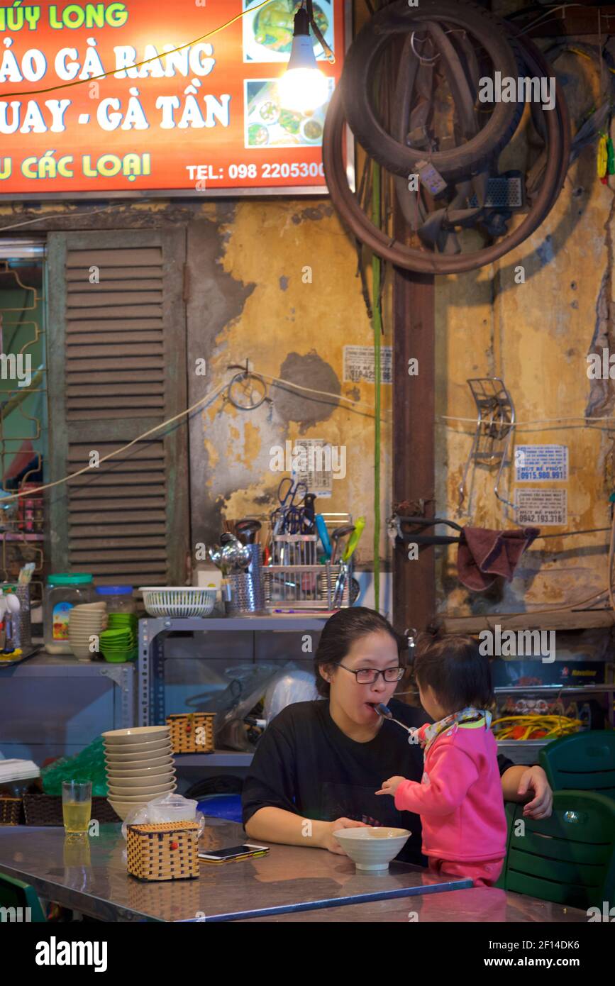 Mther and child eating at a roadside cafe, Hanoi, Vietnam Stock Photo ...