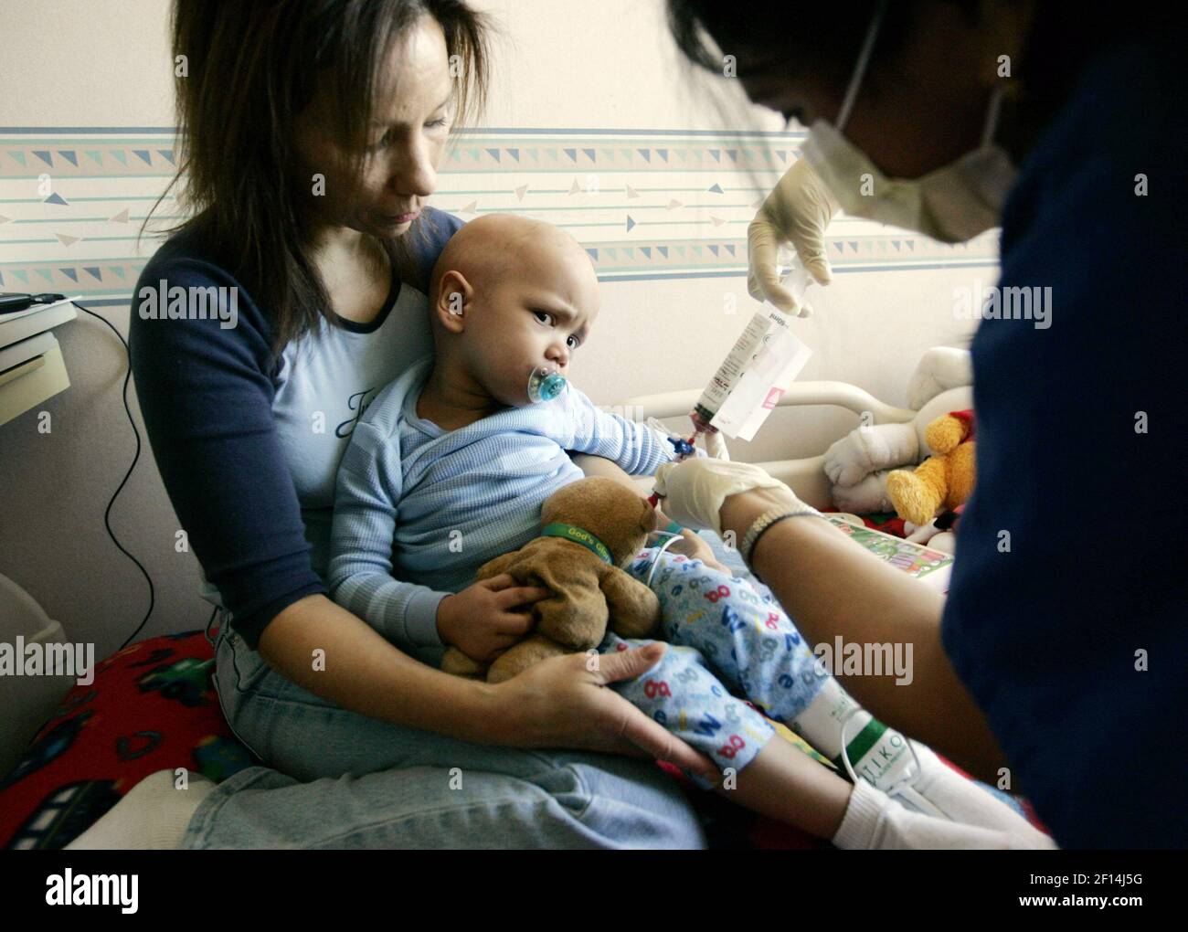 Two-year-old Caden Ledbetter, of Coppell, Texas, sits on his mother ...