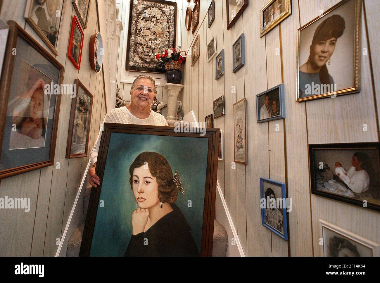 Maria "Lucy" Lopez holds a painting of her mother Juanita Torres Lara ...
