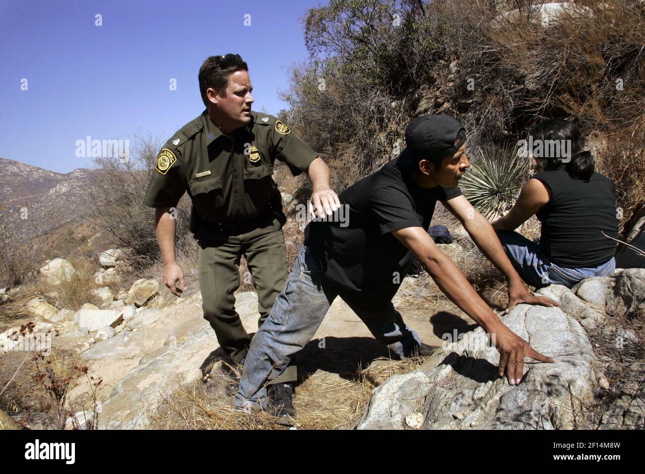 Border Patrol agent James Jacques takes two immigrants into custody who ...
