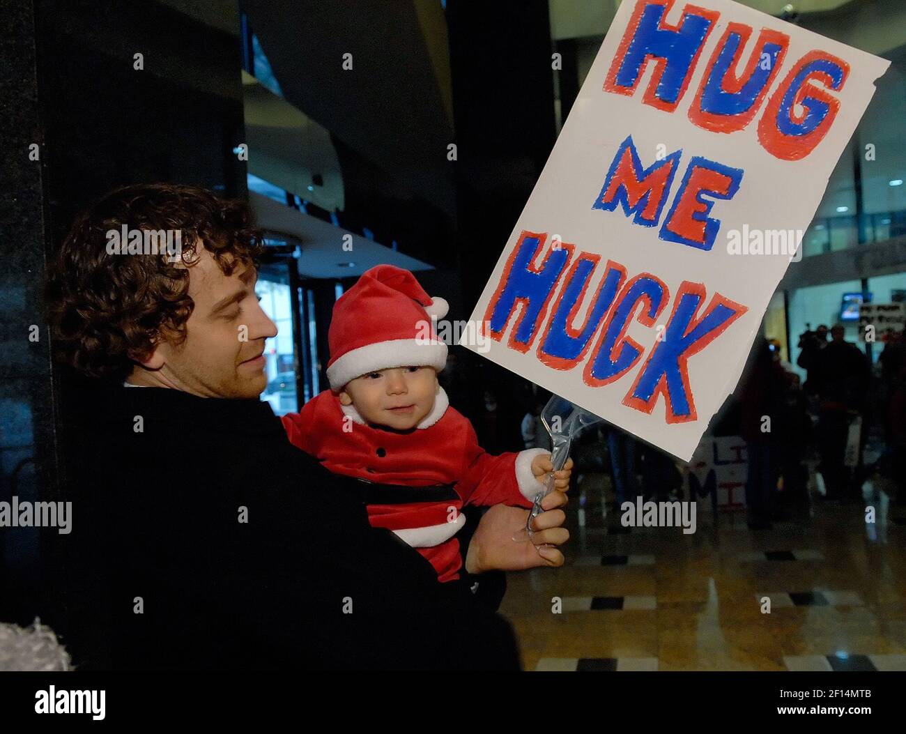 Matt Simone and his nine-month-old son, Gavin Simone, hold a "Hug Me ...