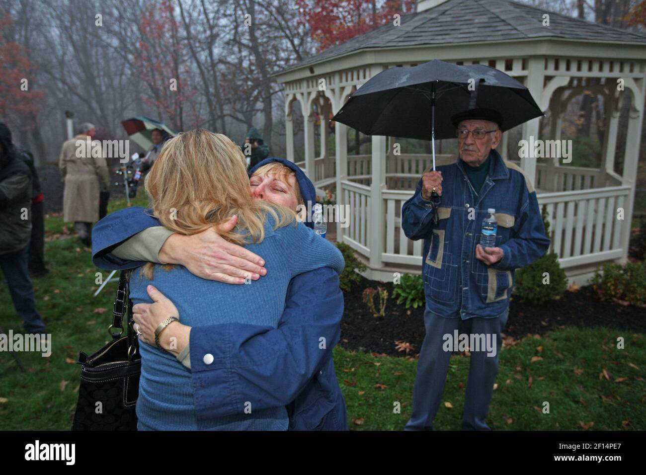 Mary Beth Pedlow, facing camera, gives a hug to Cheryl Friend just ...