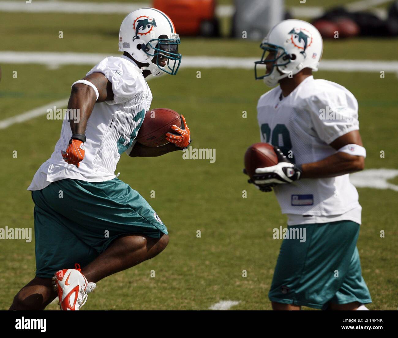 Miami Dolphins running back Ricky Williams, left, runs past fellow back ...