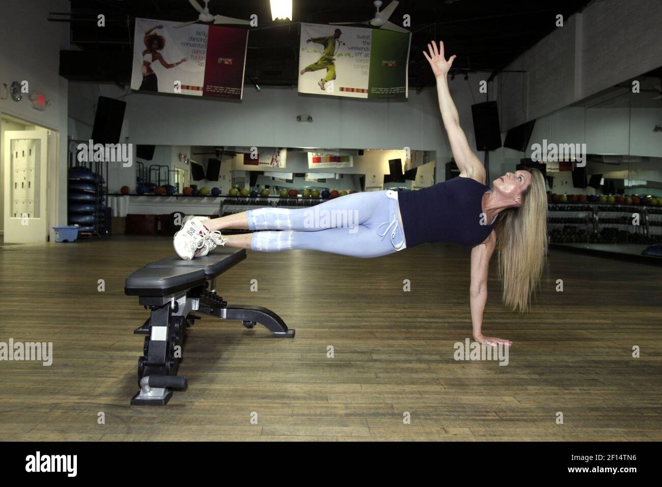 Trainer Nancy Cole demonstrates the one arm bench twist at Body and ...