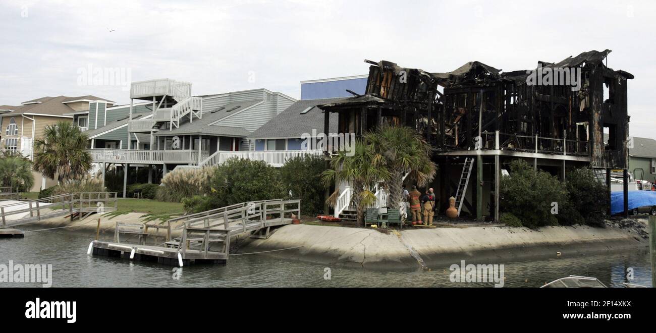 Firefighters look over the scene of a house fire on Sunday, October 28 ...