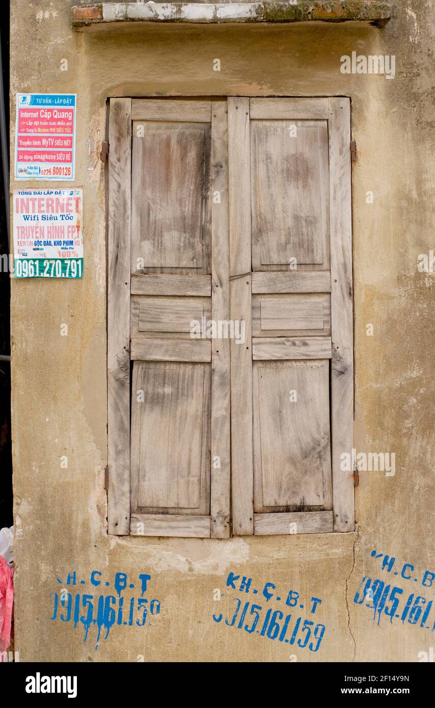 Vietnamese wooden-shuttered window and wall posters. Thanh Liêm, Hà Nam ...