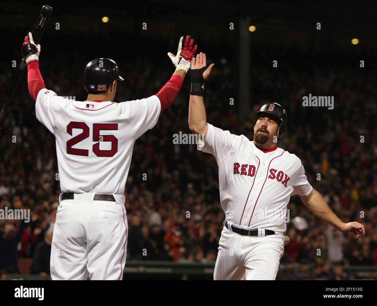 Boston Red Sox's Mike Lowell (left) greets Kevin Youkilis, who scores ...