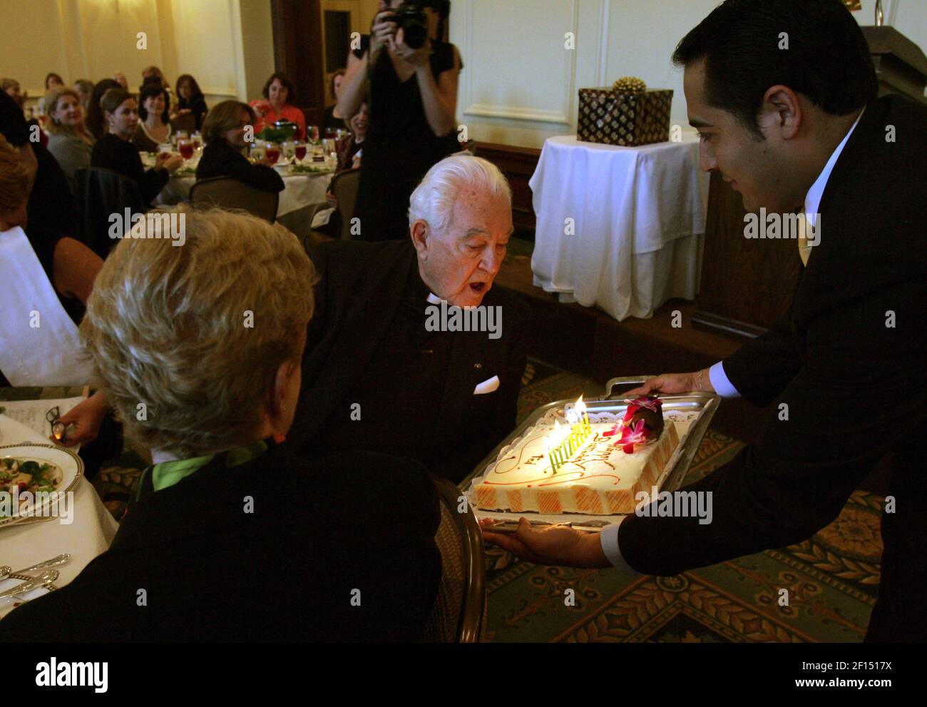 The Rev. Ted Hesburgh, center, former Notre Dame president, blows out ...