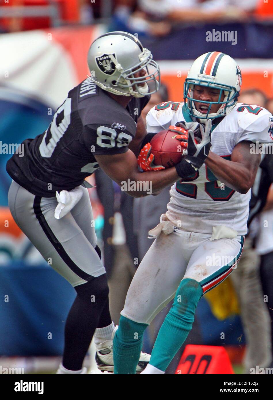 Oakland Raiders receiver Ronald Curry (left) takes the ball from Miami ...