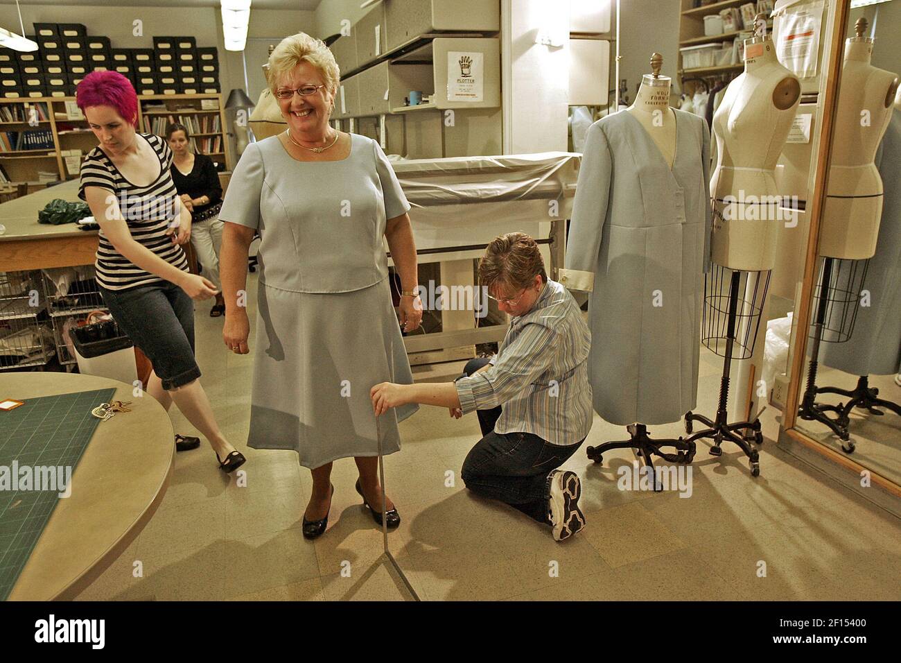 Dr. Linda Timm, president of Mount Mary College, center, is fitted for ...
