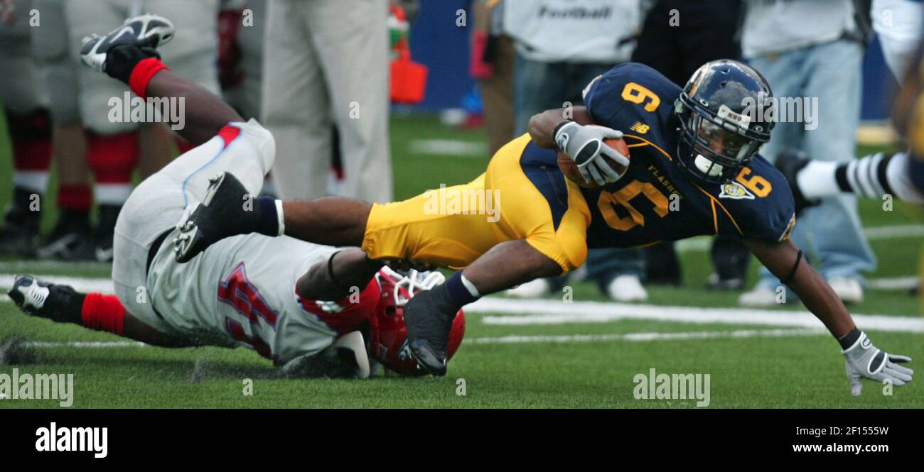 Kent State running back Eugene Jarvis, right, is tackled by Delaware ...