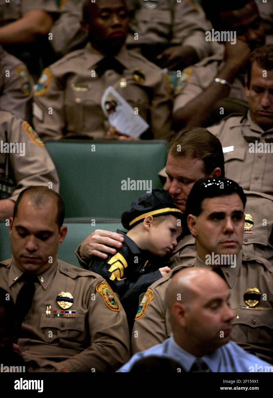 Joshua Edwards, 4, dressed in a police costume, snuggles up against his ...