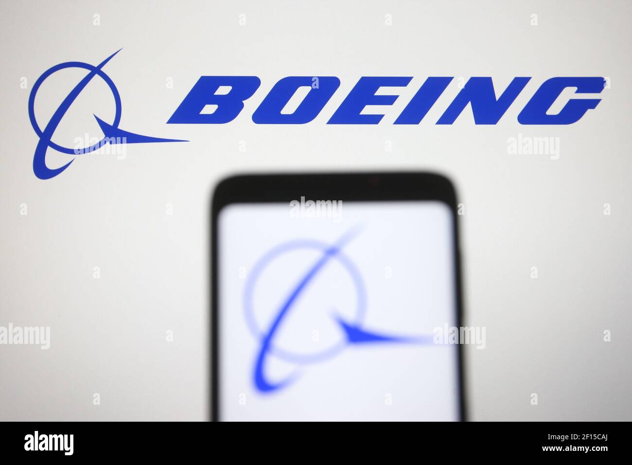In this photo illustration a Boeing logo is seen on a smartphone and a ...