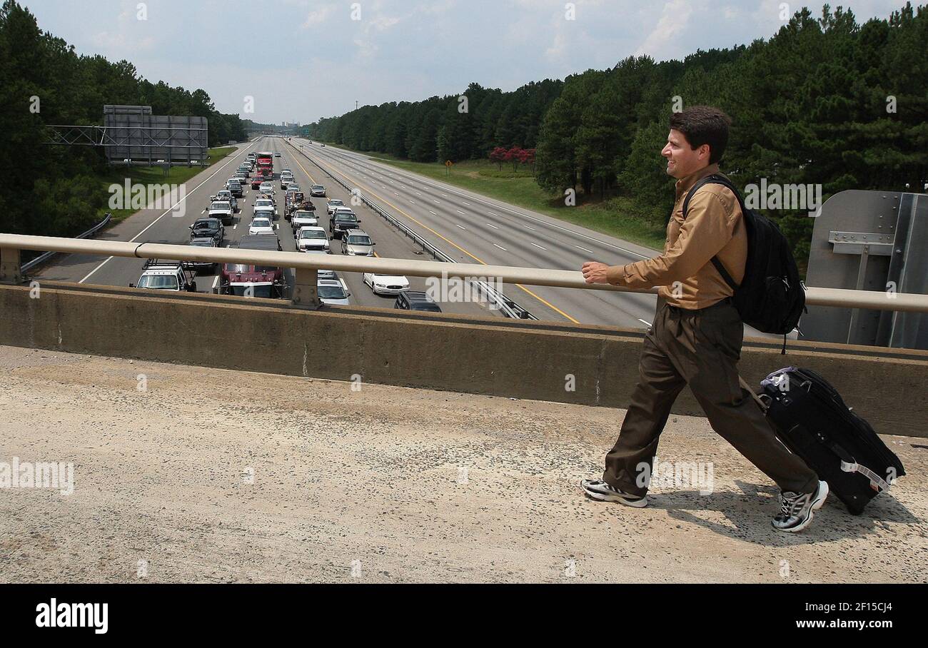 Mike Seebold, of Cary, walks across the I-40 bridge at Aviation Parkway ...