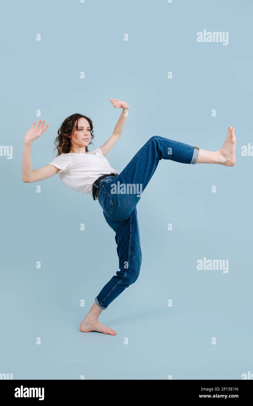 Expressive contemporary dancer poses in front of blue studio background ...