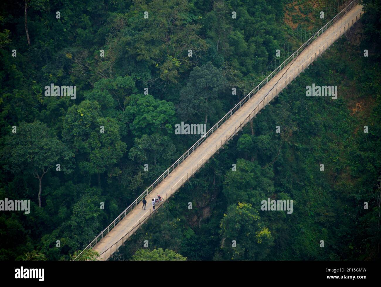 Couple on a motorbike crossing a suspension bridge. Aerial perspective ...