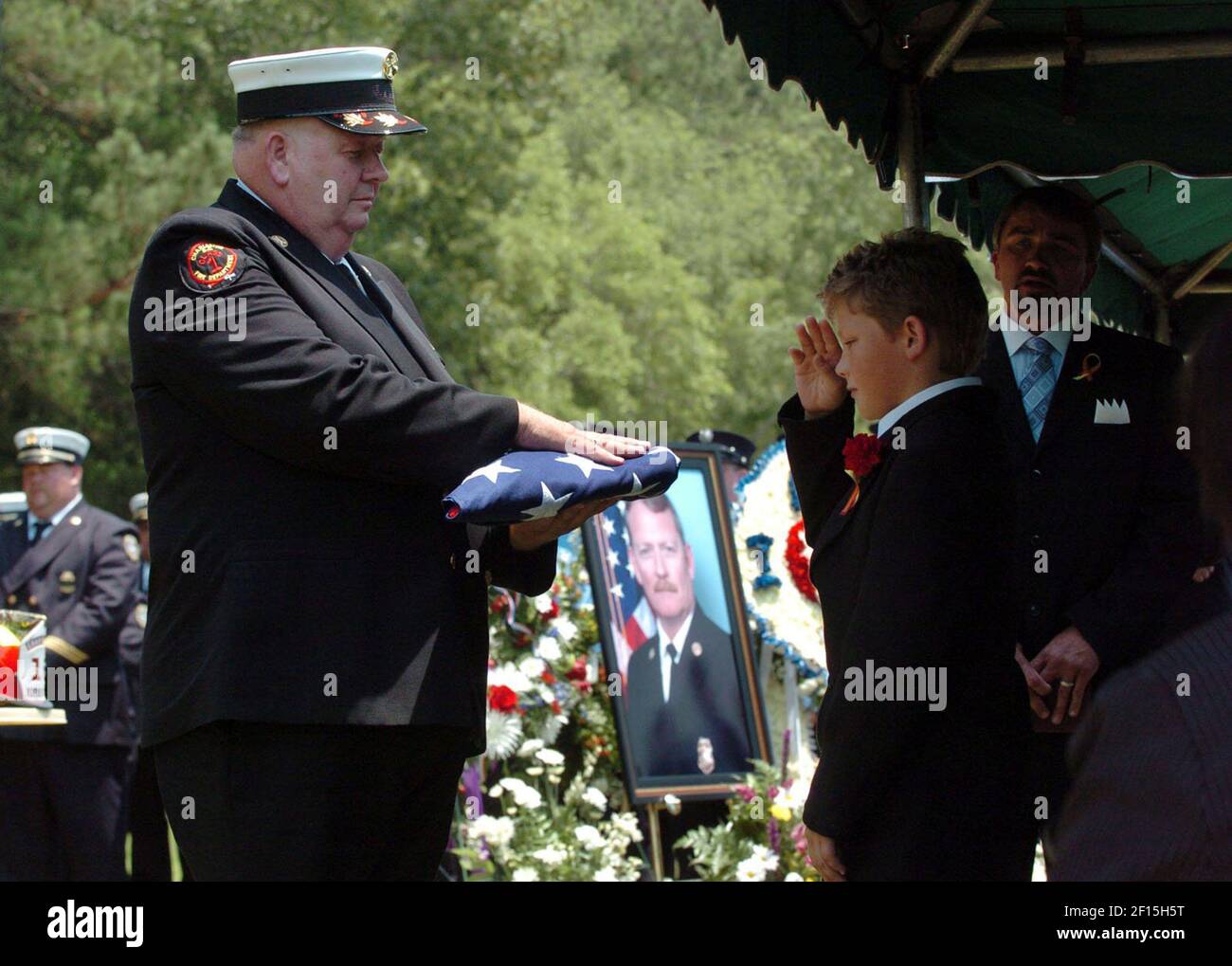 Assistant Chief Larry Garvin is saluted by Capt. Mike Benke's son ...