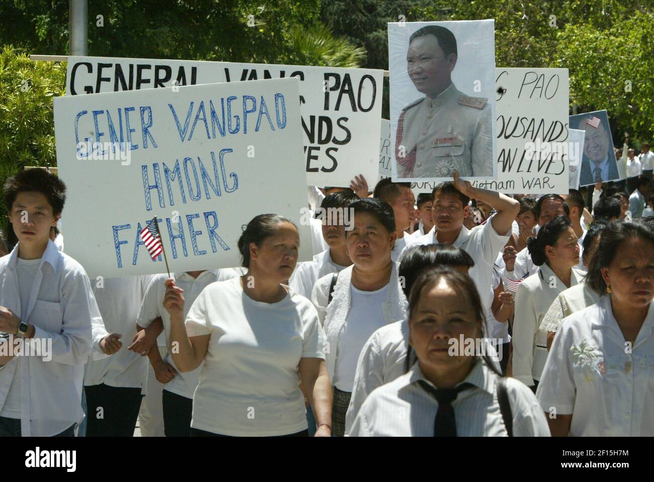 Marchers carry a signs with a combination of photographs of General ...