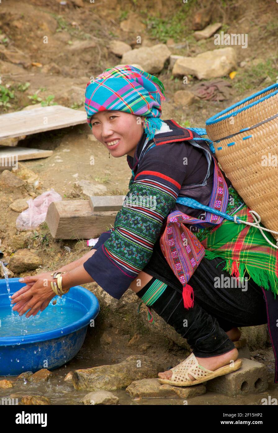 Young Hmong woman washing her hands with water from a standpipe. Sapa ...
