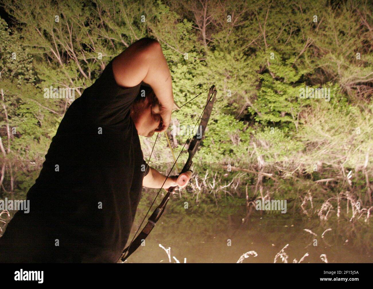 Scott Whitehead takes a shot on a carp in the nighttime shallows of El Dorado Reservoir in ...