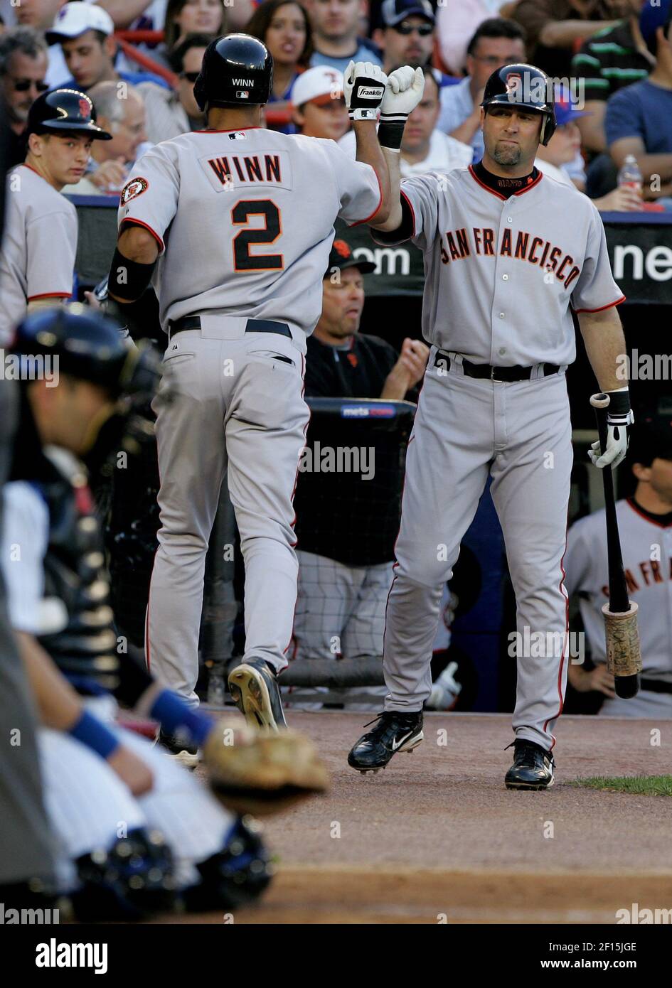 San Francisco Giants' Randy Winn is greeted at the dugout by teammates ...