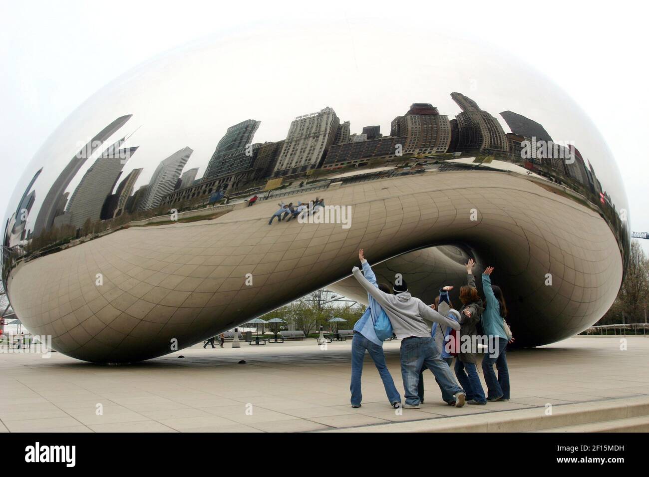 Tourists check their image in the stainless steel sculpture titled "Cloudgate" that reflects the ...