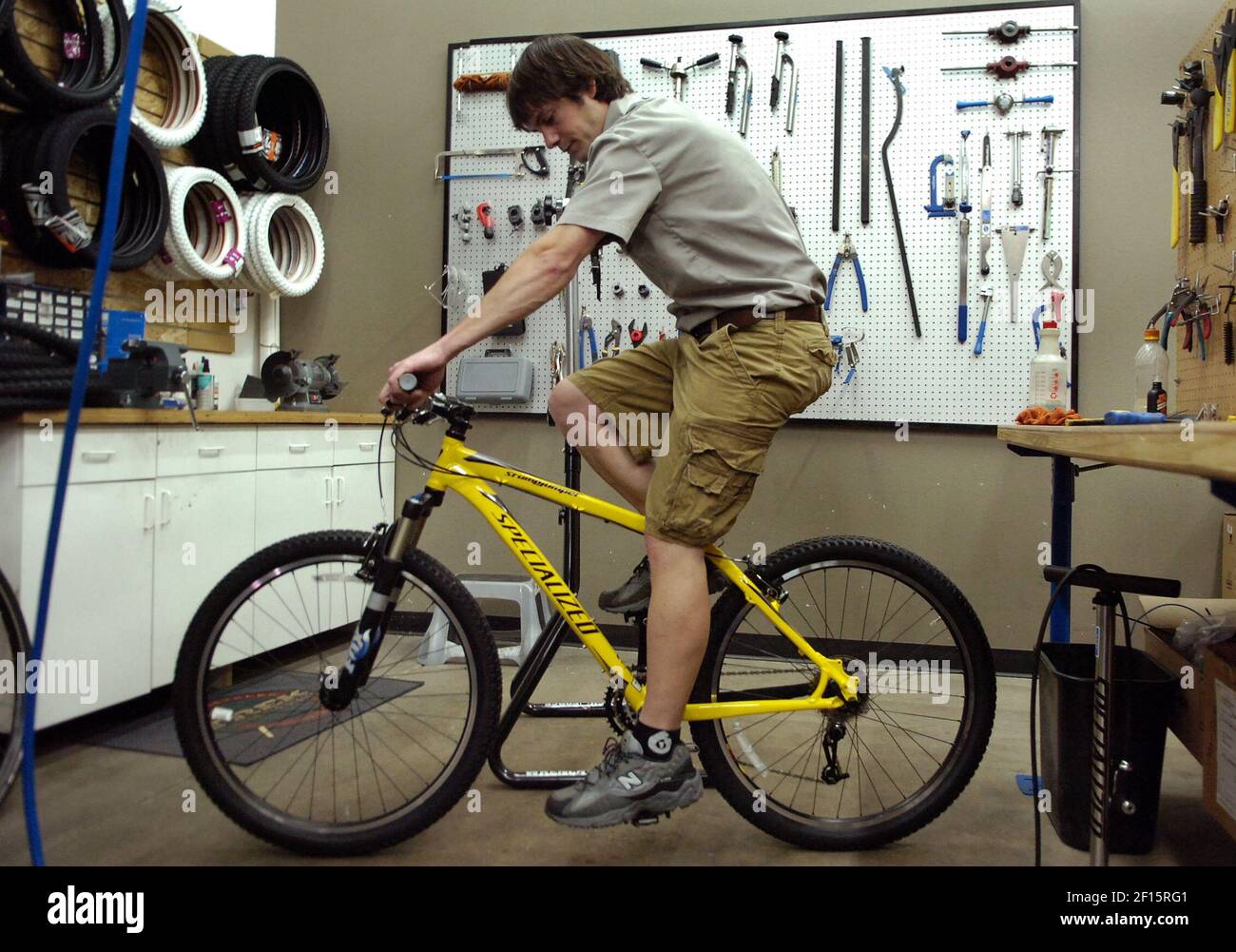 Bicycle Village mechanic Chris Kuhn tests the height of a bike seat ...