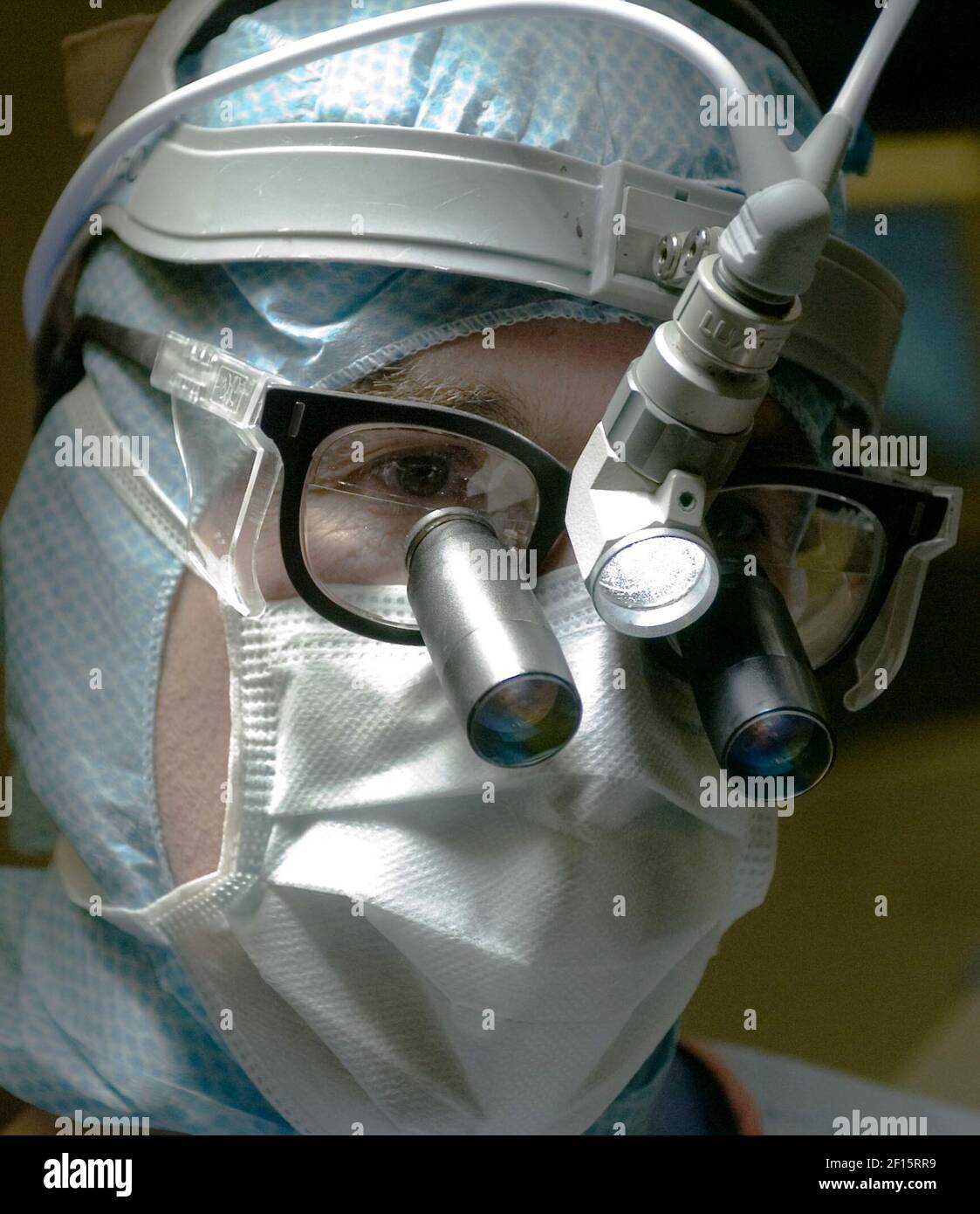 Dr. Francis Sutter wears a magnifying loupe to oversee an operation ...