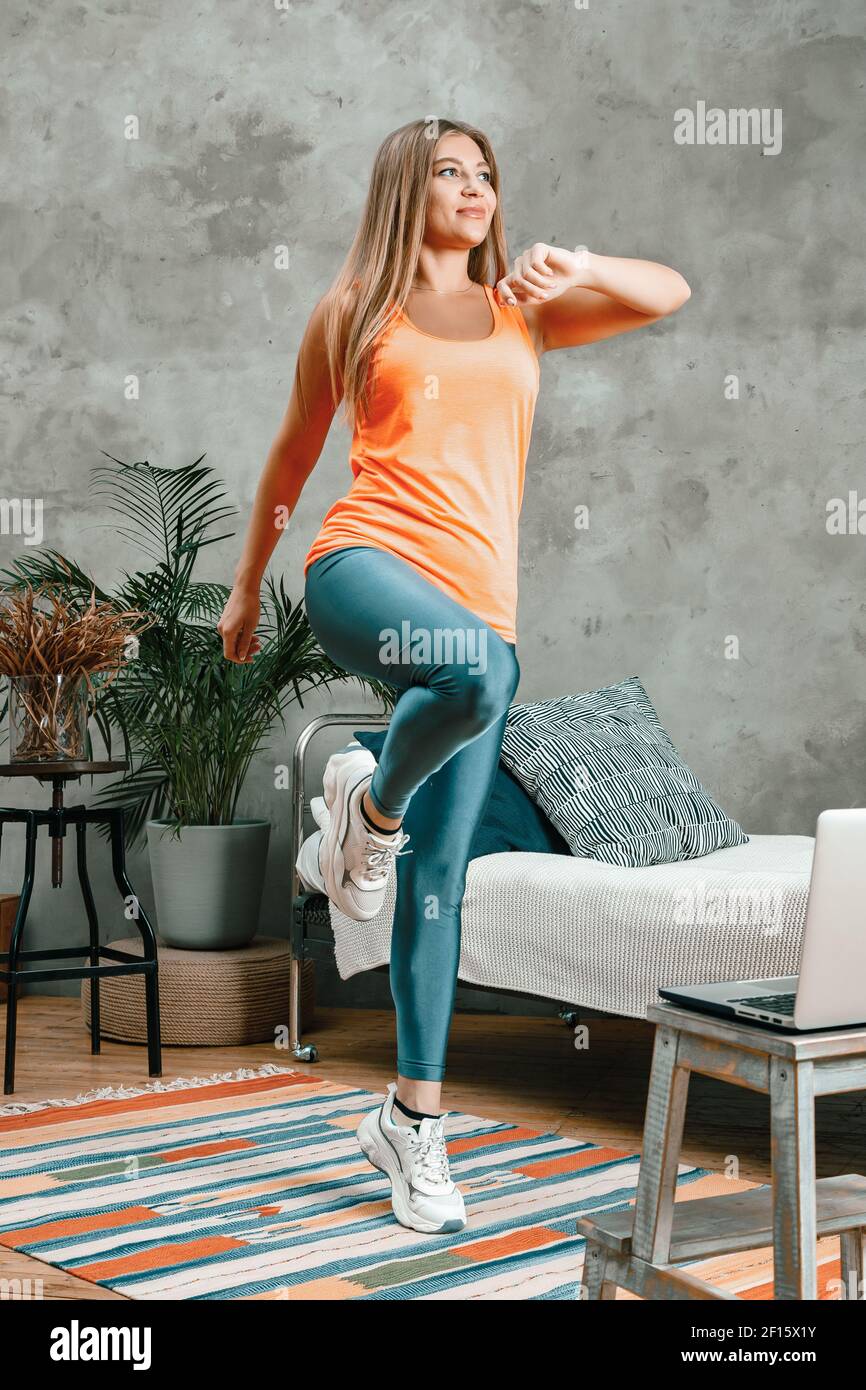 A young woman goes in for sports at home, online workout . The athlete ...