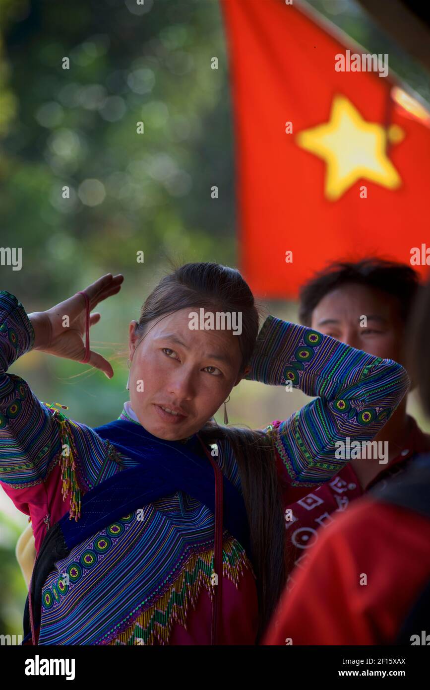 Flower Hmong woman in local style attire tyeing up her hair. Vietnamese ...