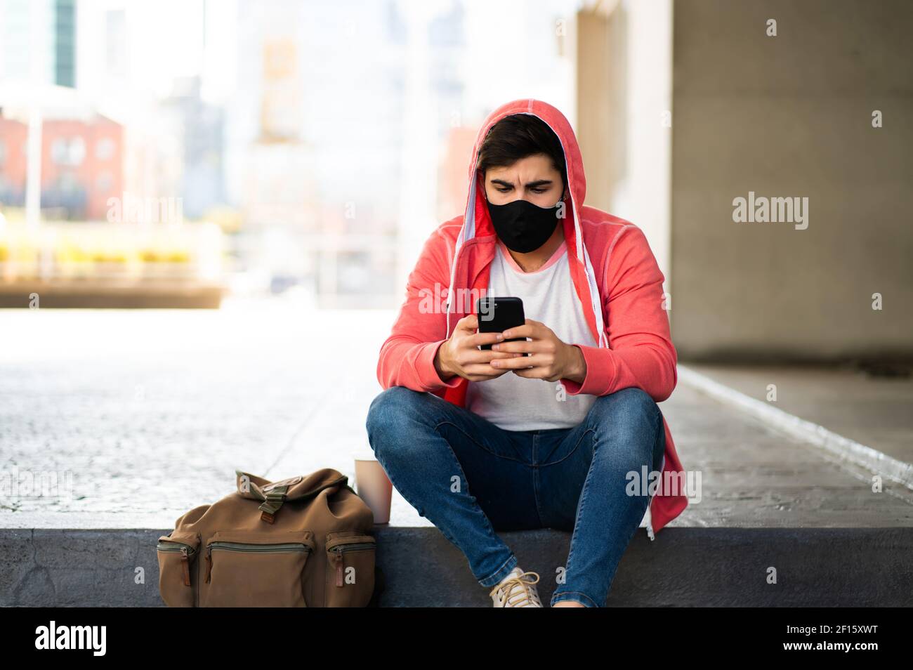 Young man using his mobile phone outdoors Stock Photo - Alamy