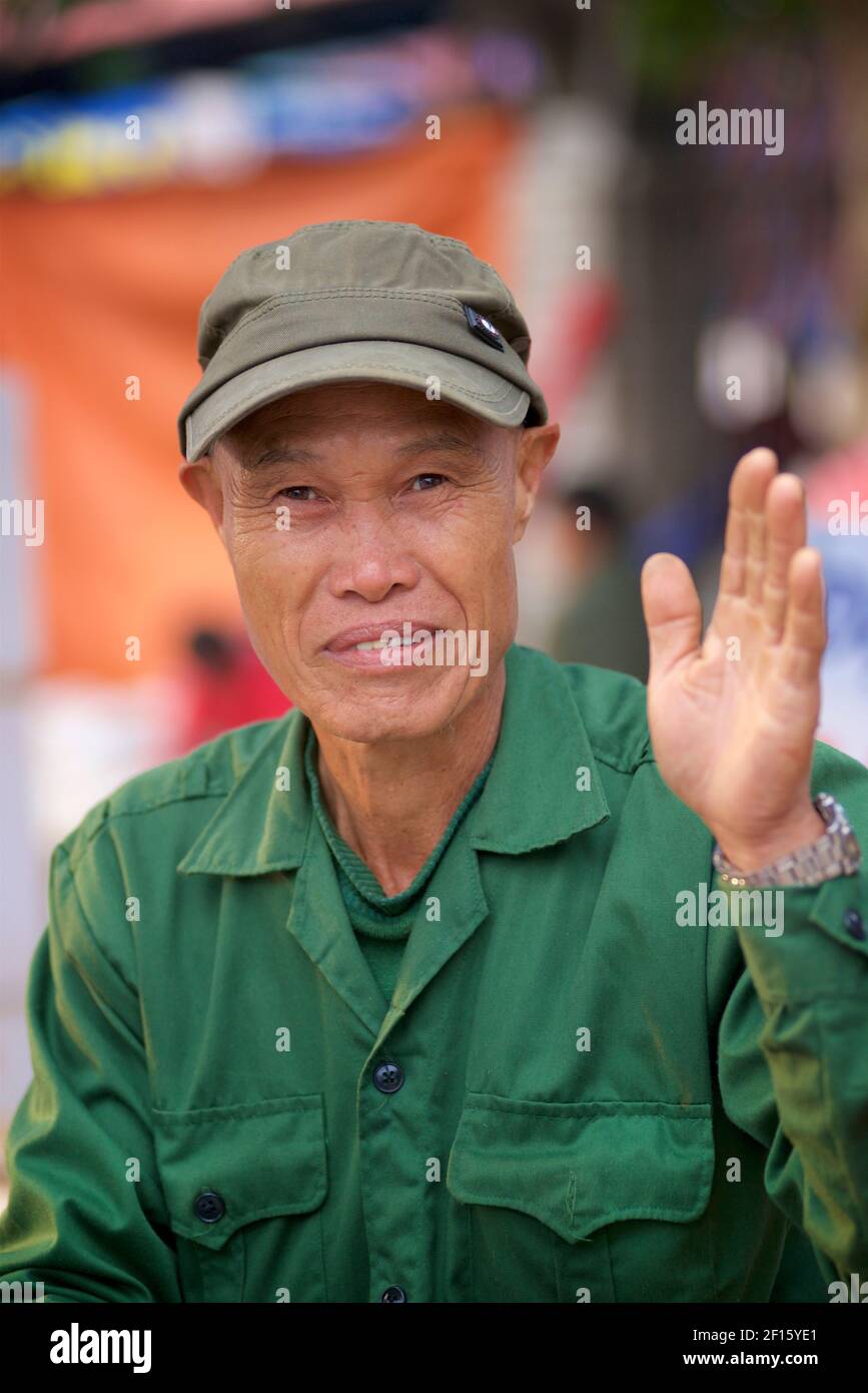 Friendly, elderly Vietnamese man in military style green uniform. Bac ...