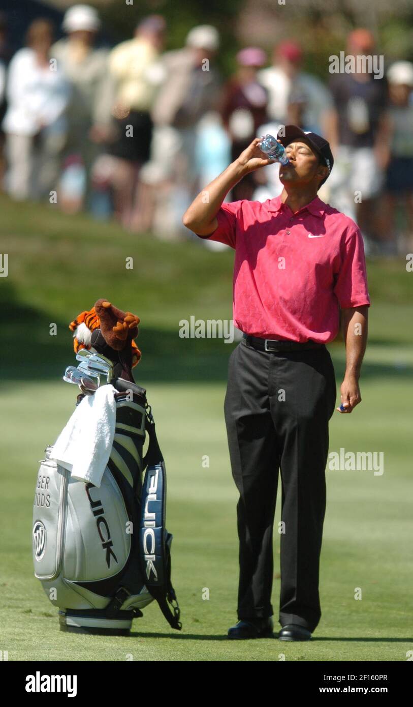 Tiger Woods cools off with a cold drink on the ninth fairway at the ...