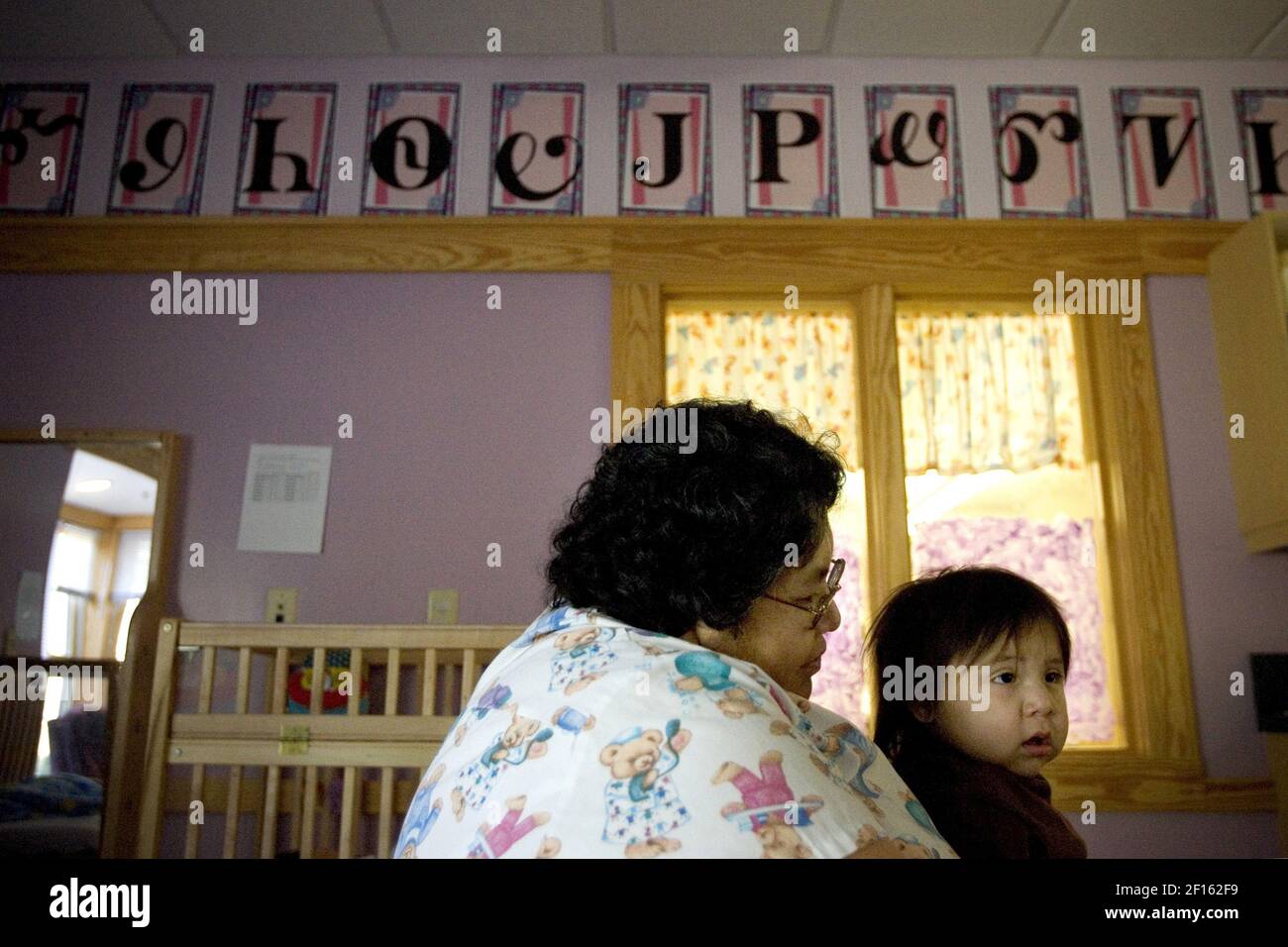 Cherokee immersion daycare teacher Stacy Rogers sits with 15-month-old ...