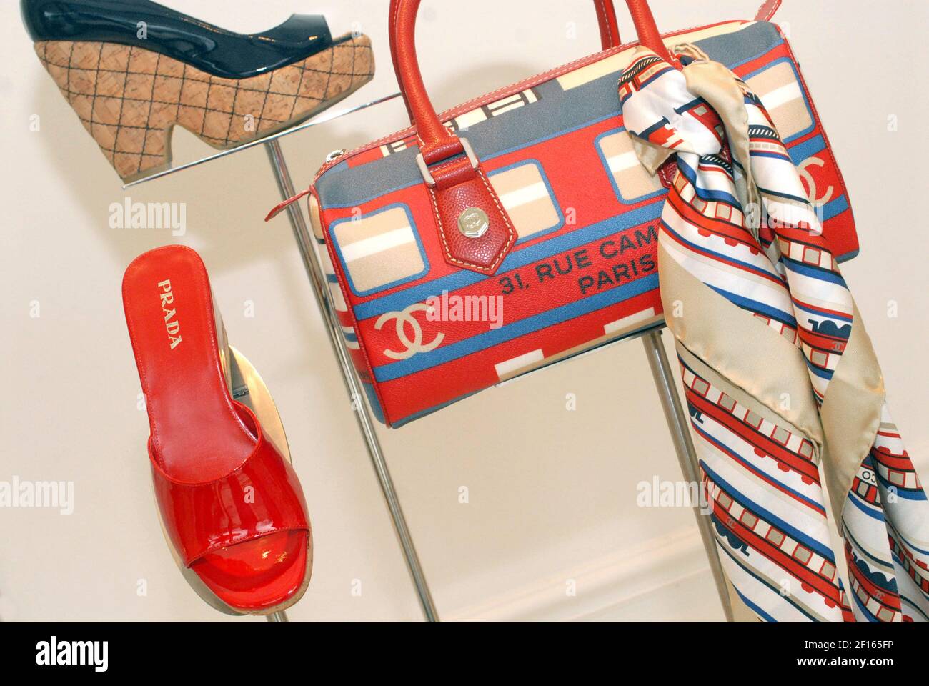 Red bag, $1,150.00; Black shoe, $595.00; Scarf, $295.00 all by Chanel. Red shoe by Prada, $395. ...