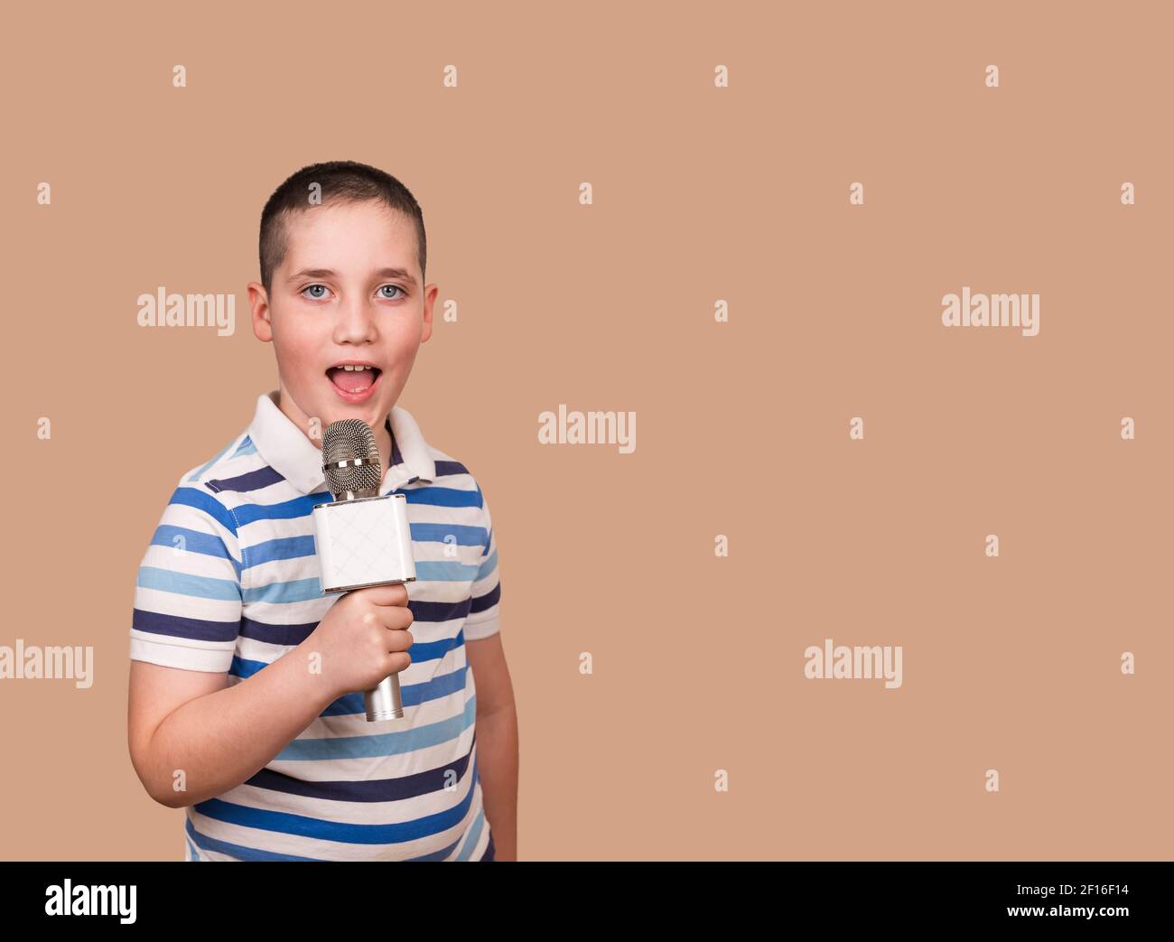 Singing child holds microphone in his hands. Boy is recording his song ...