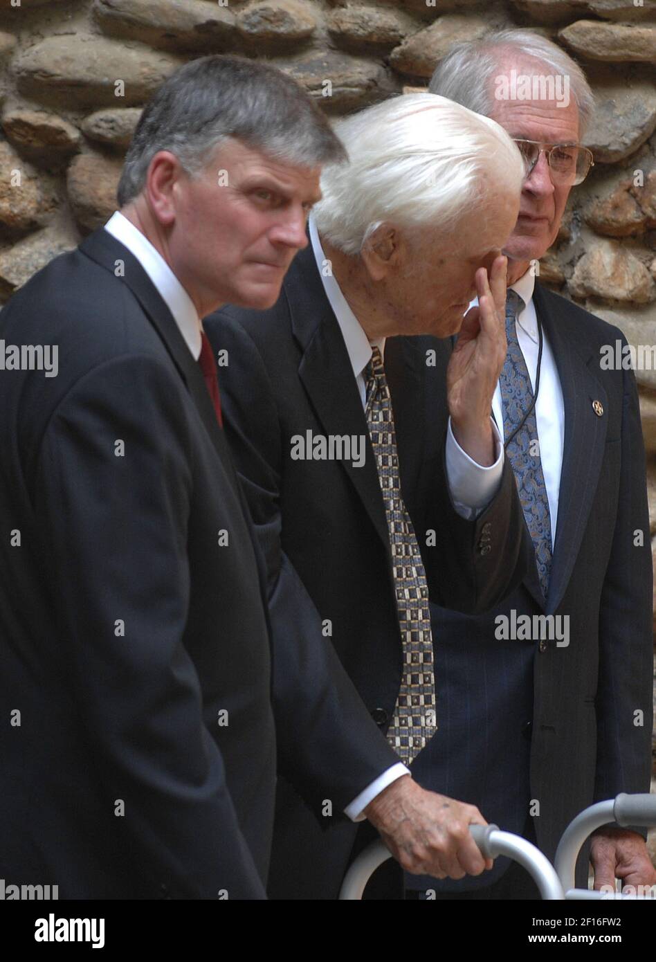 Evangelist Billy Graham, center, wipes his eye as he leaves the service ...
