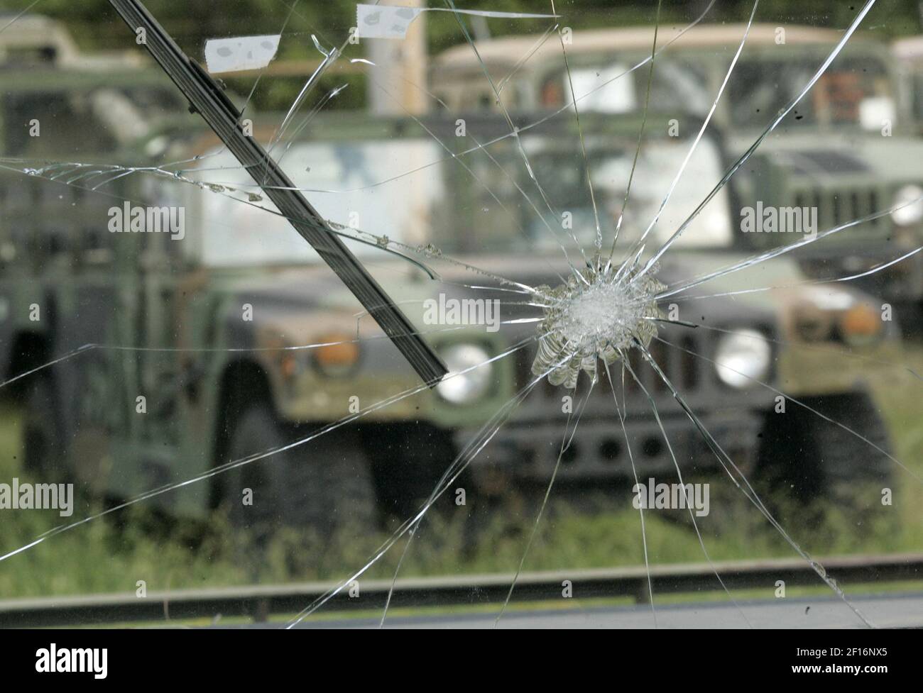 A bullet shattered windshield frames other Humvees stored at the Red ...