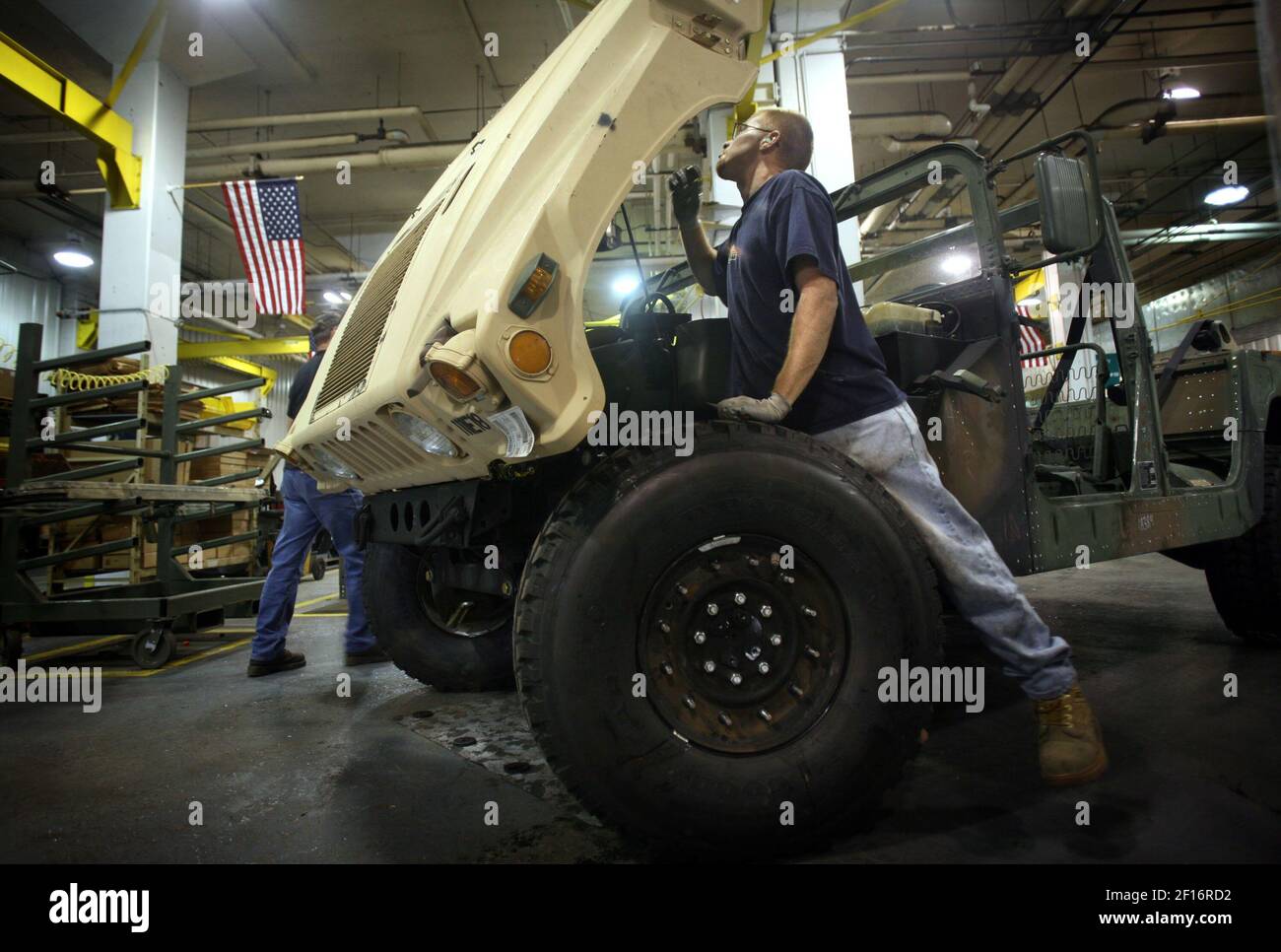 Mechanic Robert Watson installs a new hood and windshield on a Humvee ...