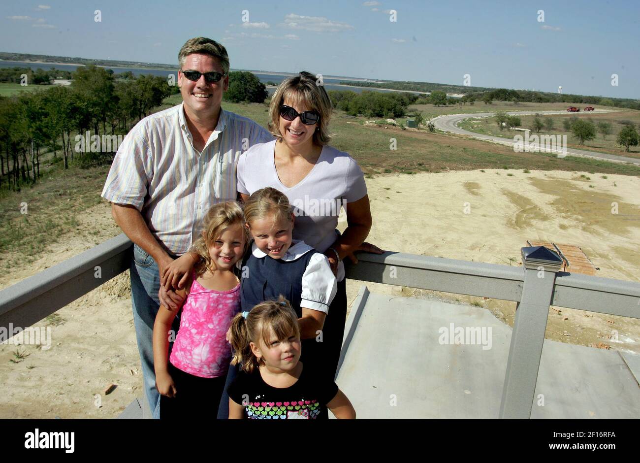 Kirk Alland, left, and his wife, Carla Vogel, pose with their girls ...