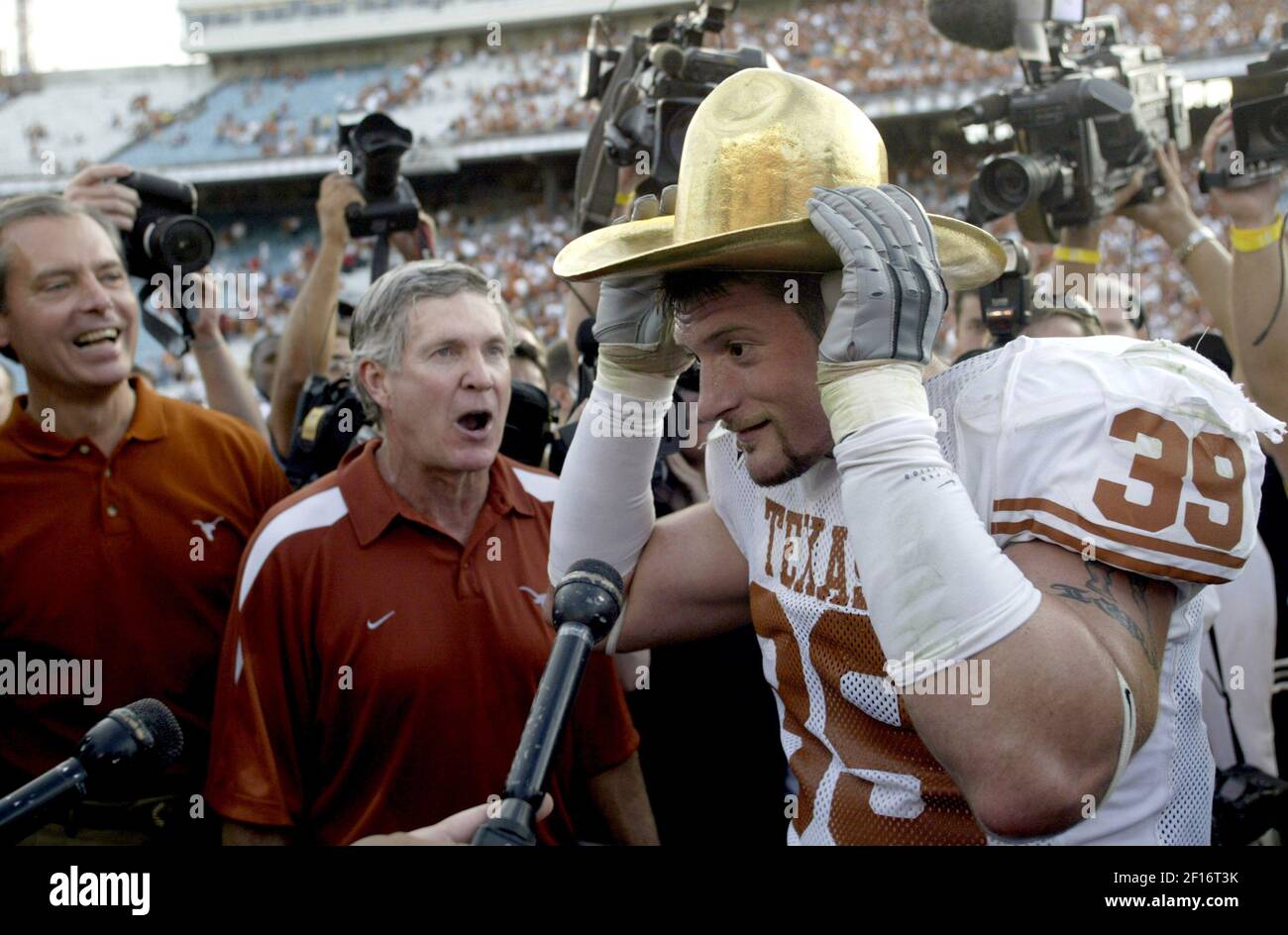 Texas head coach Mack Brown watches as Brian Robison (39) tries on the ...