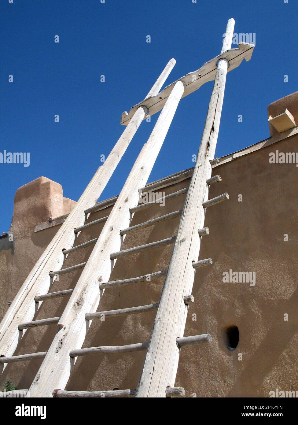 A three-pole ladder leans against the kiva at Acoma Pueblo in New ...