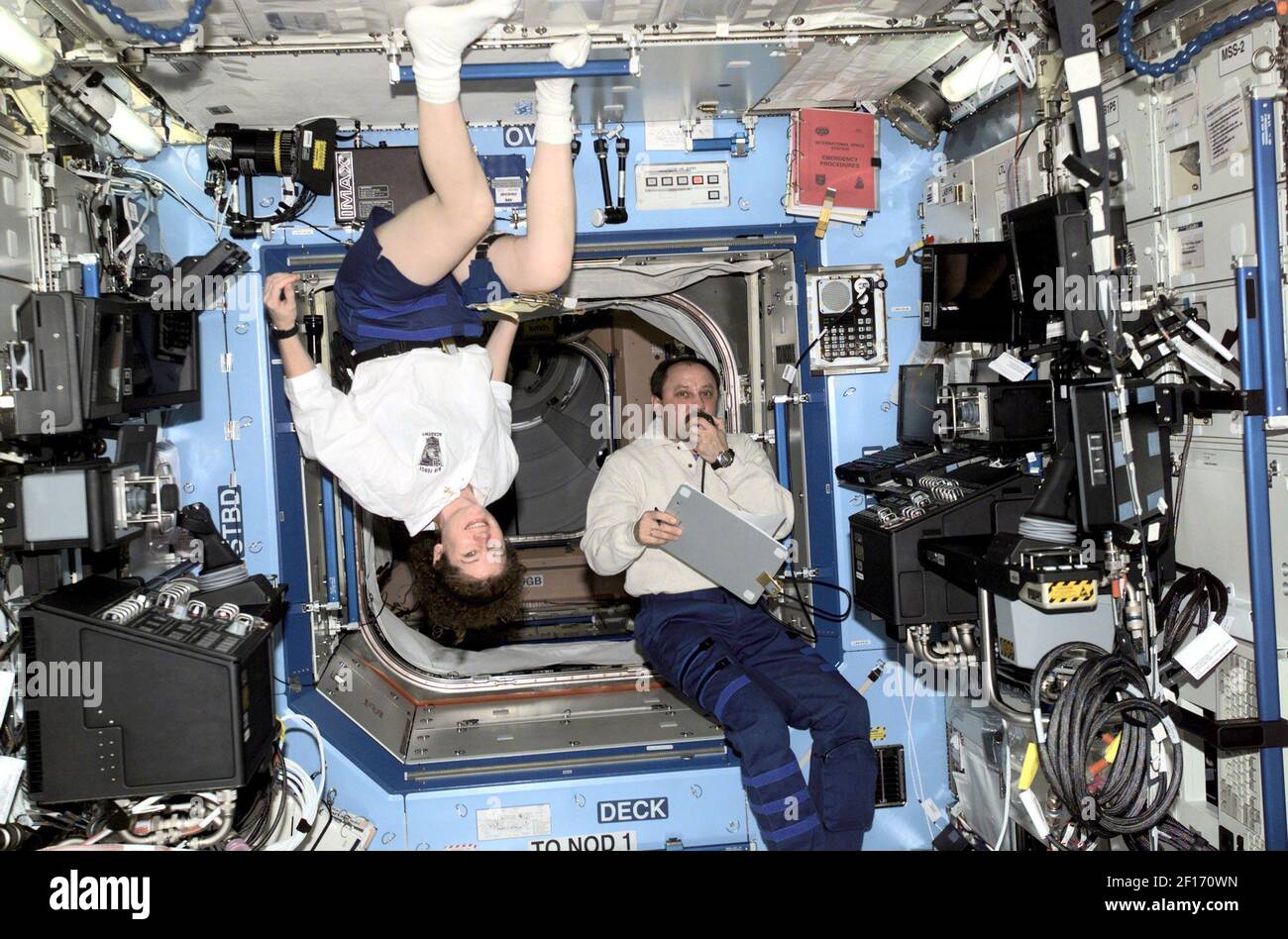 Astronaut Susan J. Helms (left), Expedition Two flight engineer, pauses ...