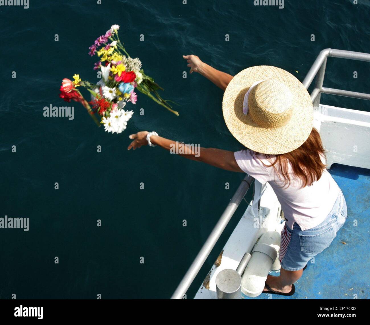 Misty Goodman tosses a bouquet of flowers into the sea after her ...