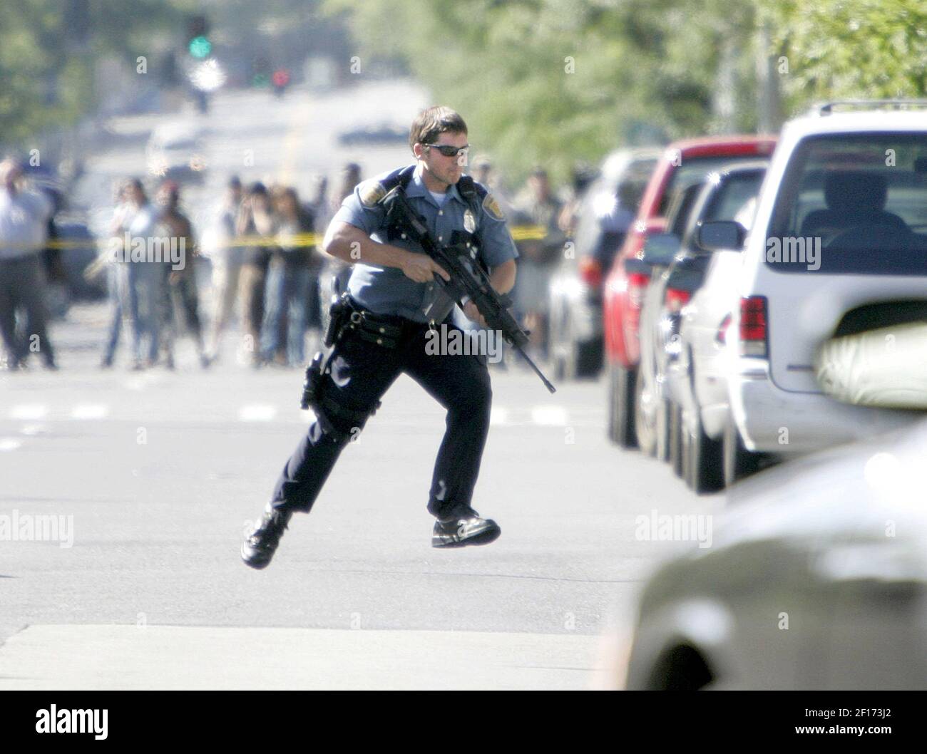 A Seattle police officer runs across the street to take cover behind a ...