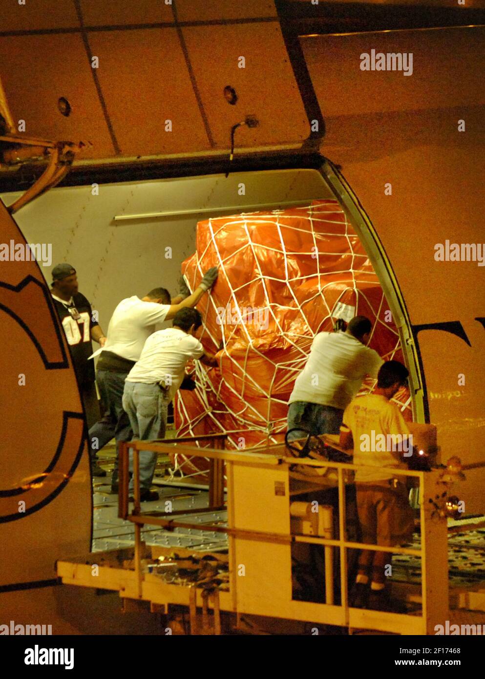 Ramp workers manage the loading of freight onto a cargo plane at Miami ...