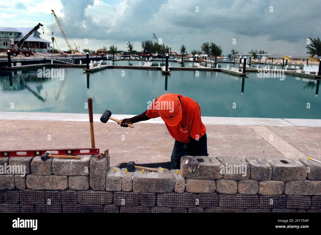 Felix Riley hammers away at a stone wall being erected near the marina ...